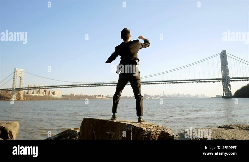 successful man standing on top raising arms for wining victory pose ...