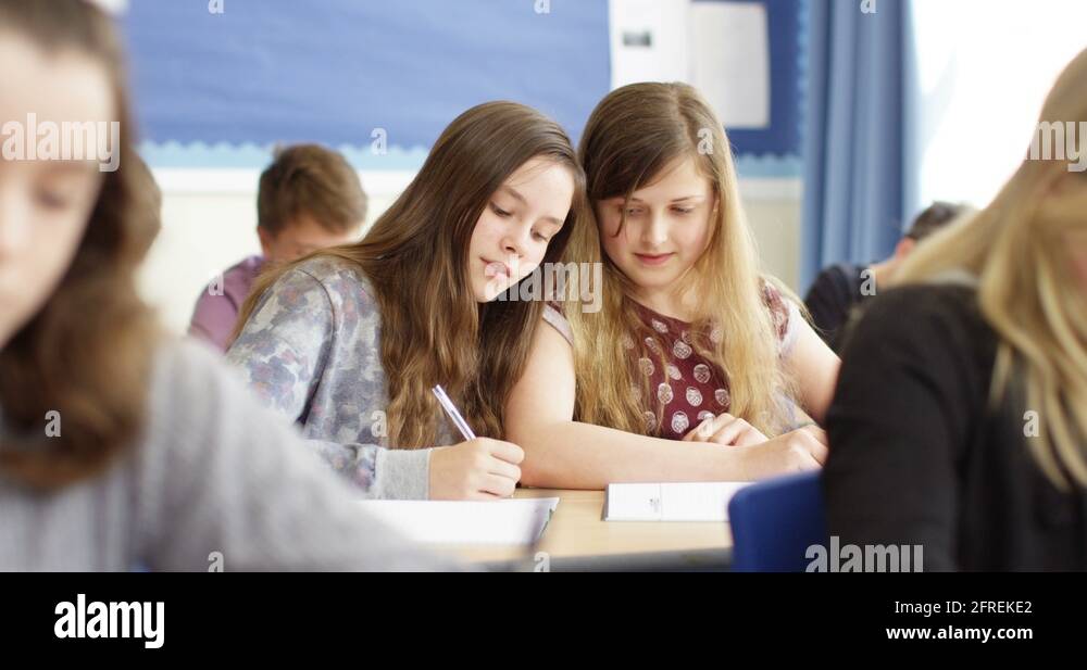 4k, Two students helping each other in a school classroom. Slow motion ...