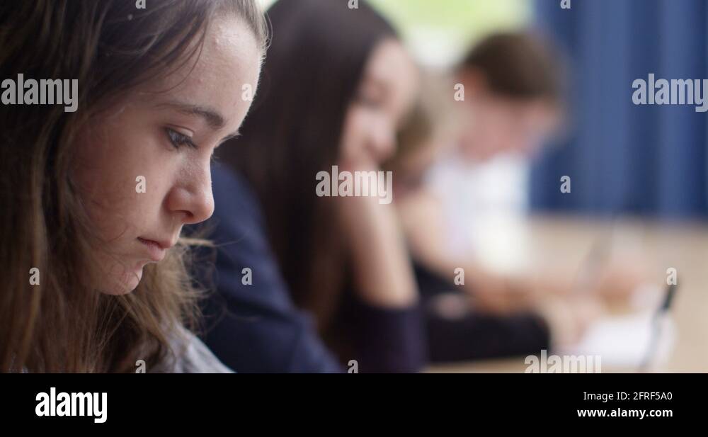 4k, Students in school uniform taking exam at desk in a classroom. Slow ...