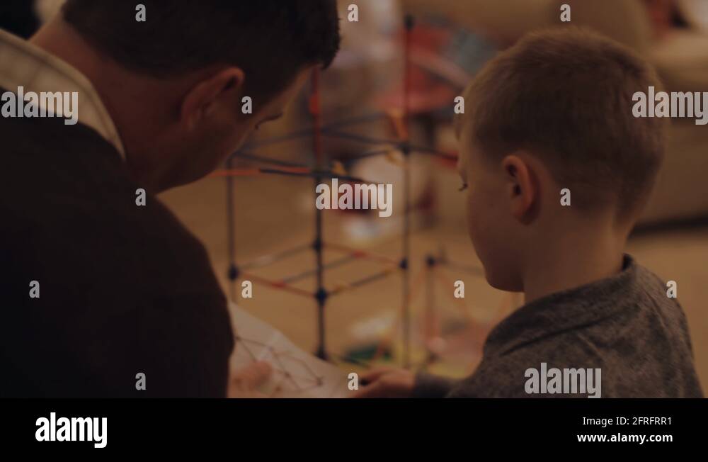 A father and son reading instructions and building a plastic toy Stock ...