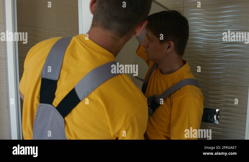 Two Men in Uniform Are Installing Partitions in Toilet Cubicles ...