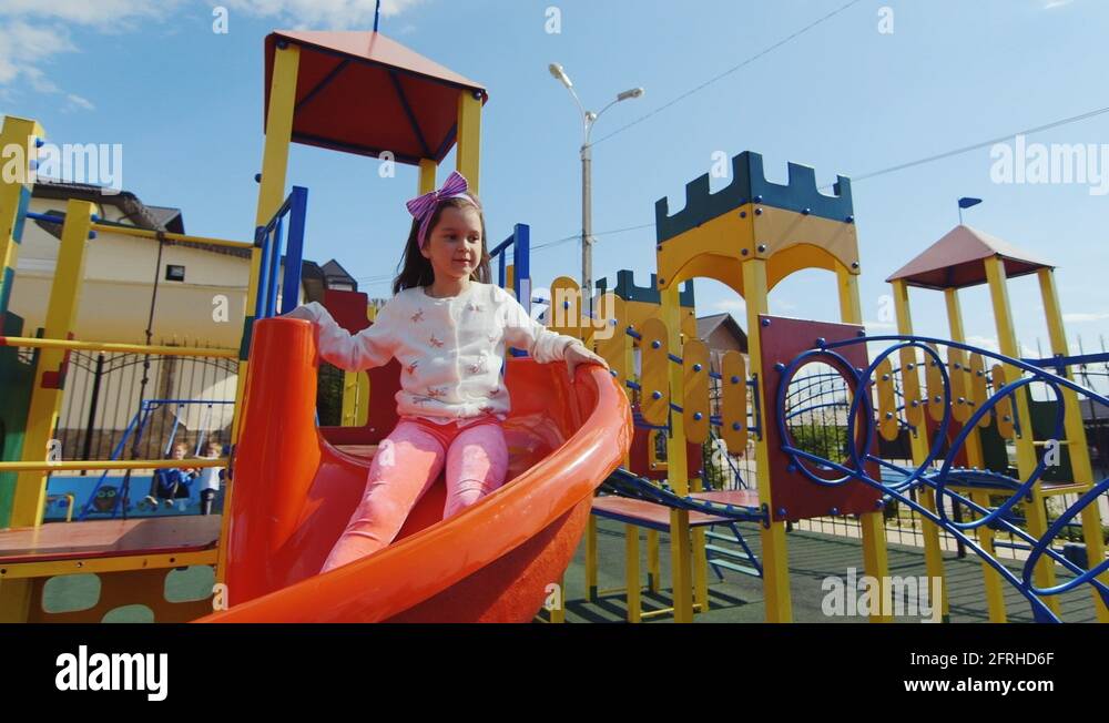 Child Sliding on a Slide in Park, Little Girl Playing at Playground ...