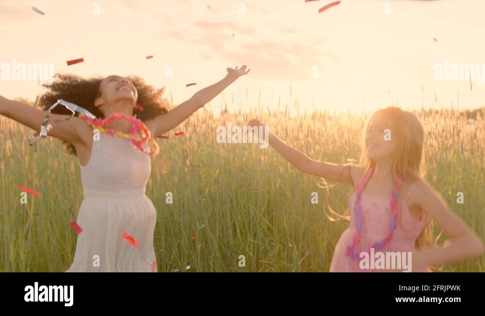 Young girls dancing in the wheat field and merrily catching the falling ...