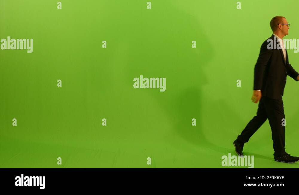 businessman walking into the frame. isolated green screen background ...