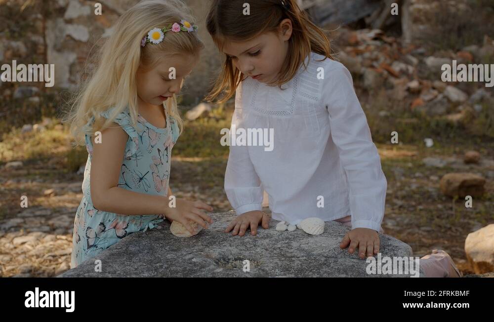 Two children playing with shells and stones Stock Video Footage - Alamy