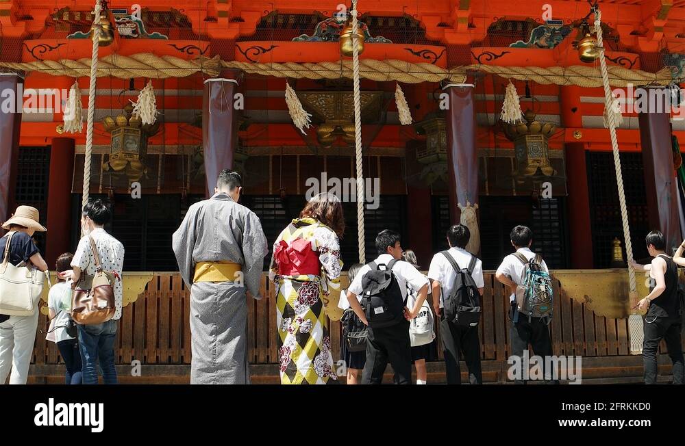 Kyoto - Visitors at Yasaka Shrine pulling ropes of Japanese Shinto ...