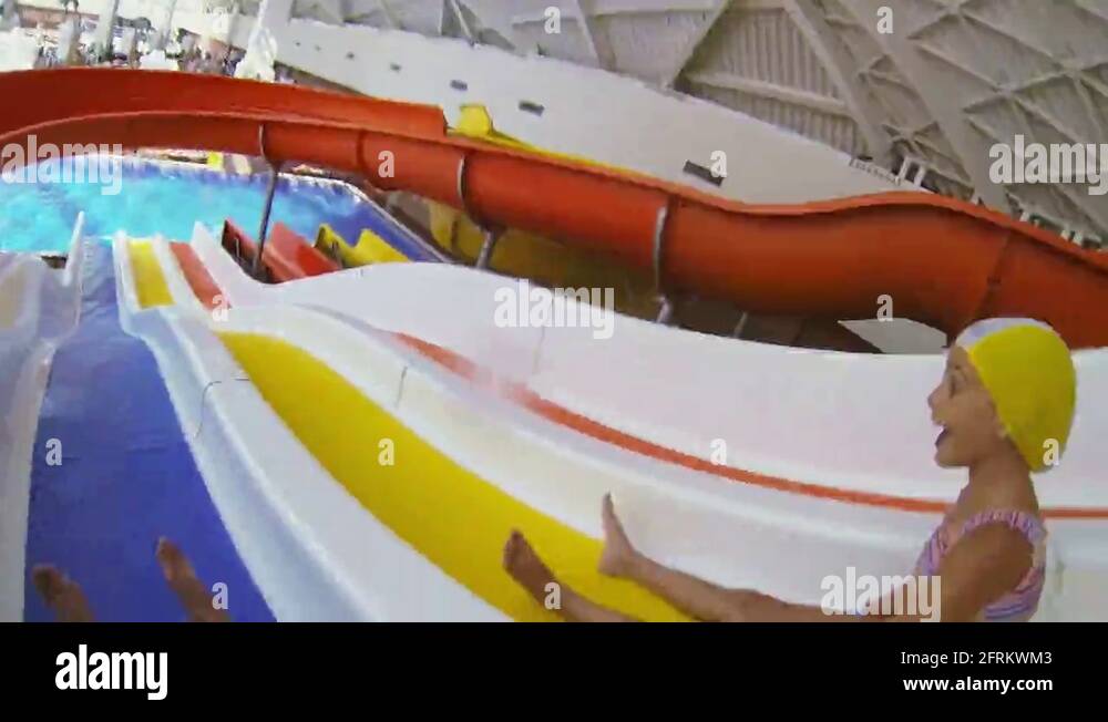Little girl slides by yellow tube to water in aquapark Stock Video ...