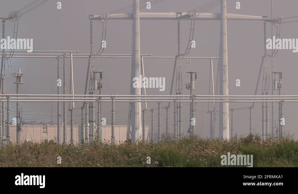Smoke from hot wildfire approaches electrical grid equipment Stock ...