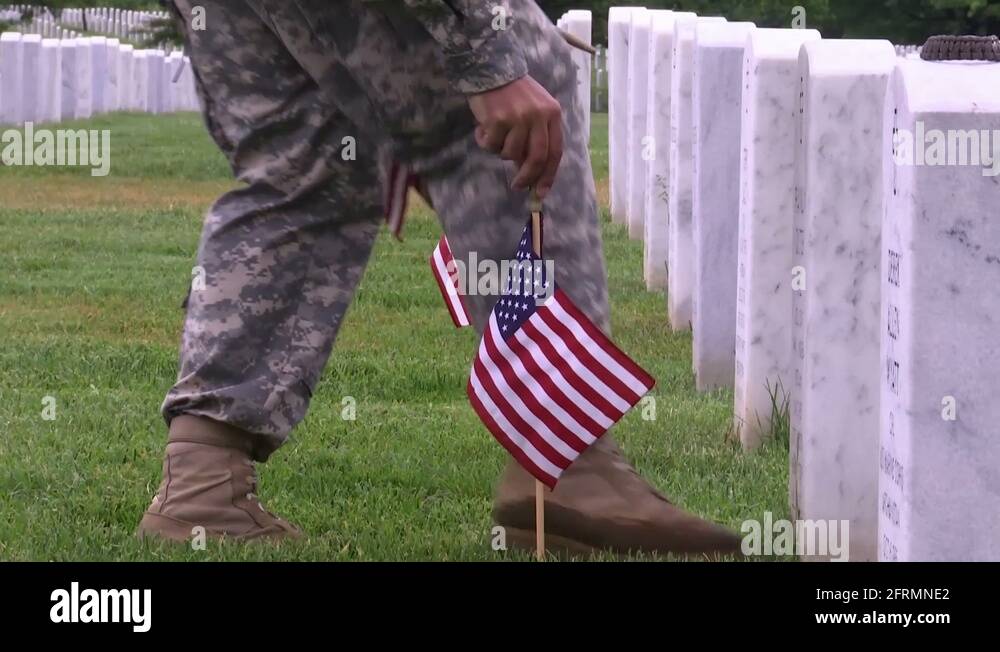 Arlington National Cemetery - Soldier placing flag at grave site Stock ...