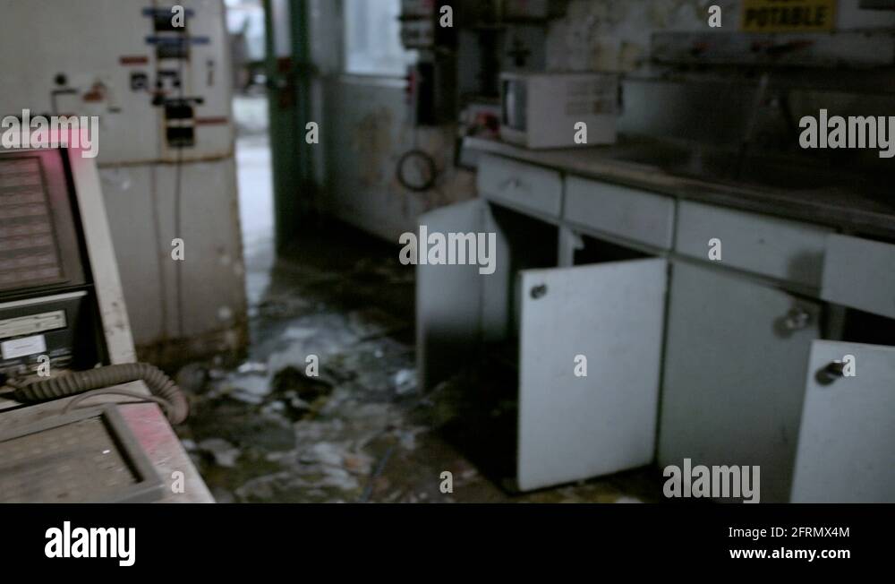 Pan shot from open, broken cupboards to an old, dusty computer in an ...