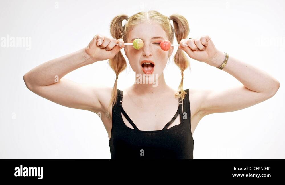 Young beautiful girl dancing, smiling, holding chupa chups over white ...