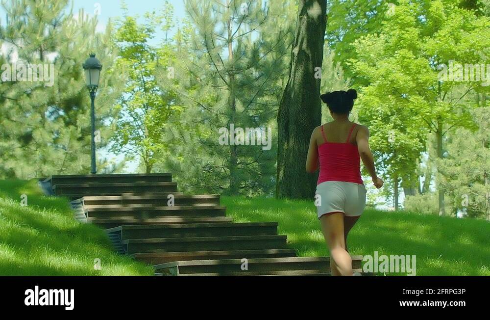 Woman run up stairs in slow motion. Girl running on stairway in park ...