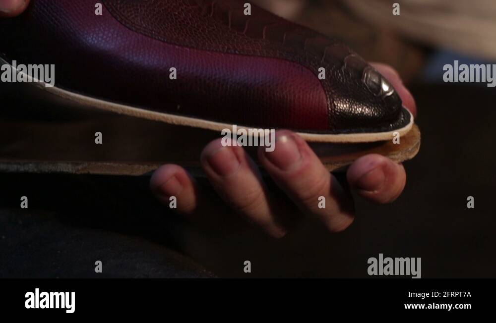Bonding shoe sole. Cobbler sews shoes. Shoemaker in the craft studio ...
