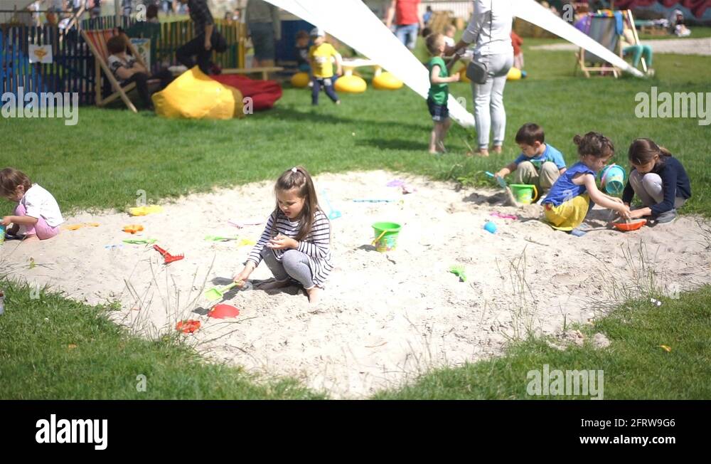 Happy children playing with sand on playground, kindergarten, summer ...