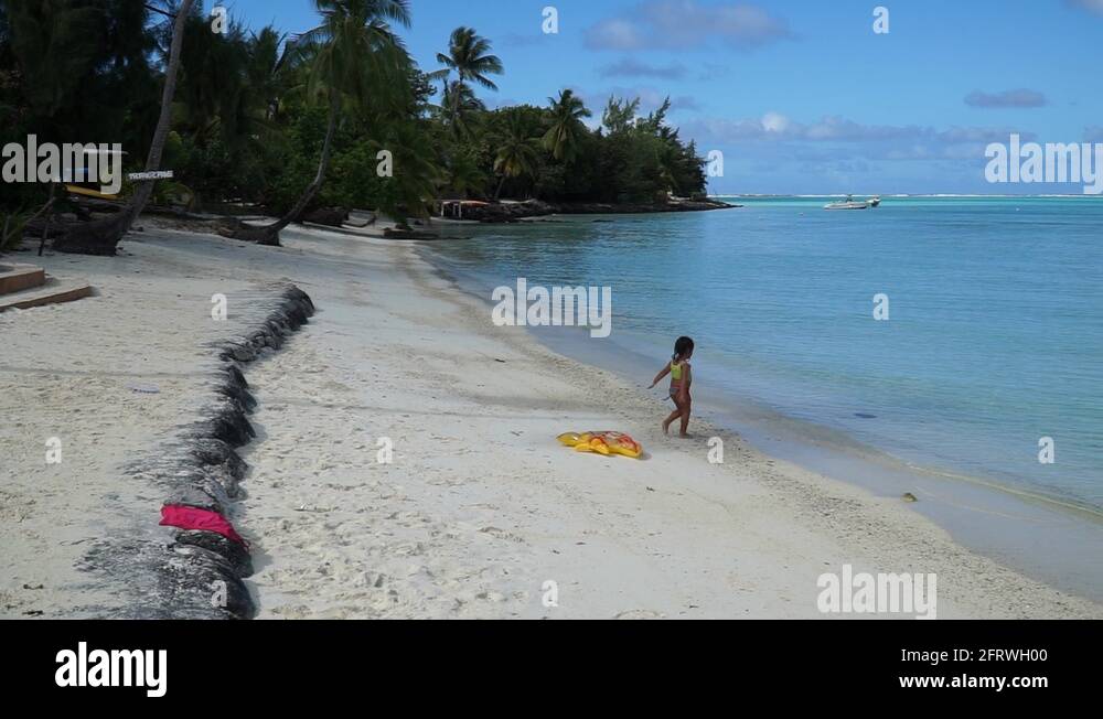 A little girl playing on a beach on Bora Bora Island, French Polynesia ...