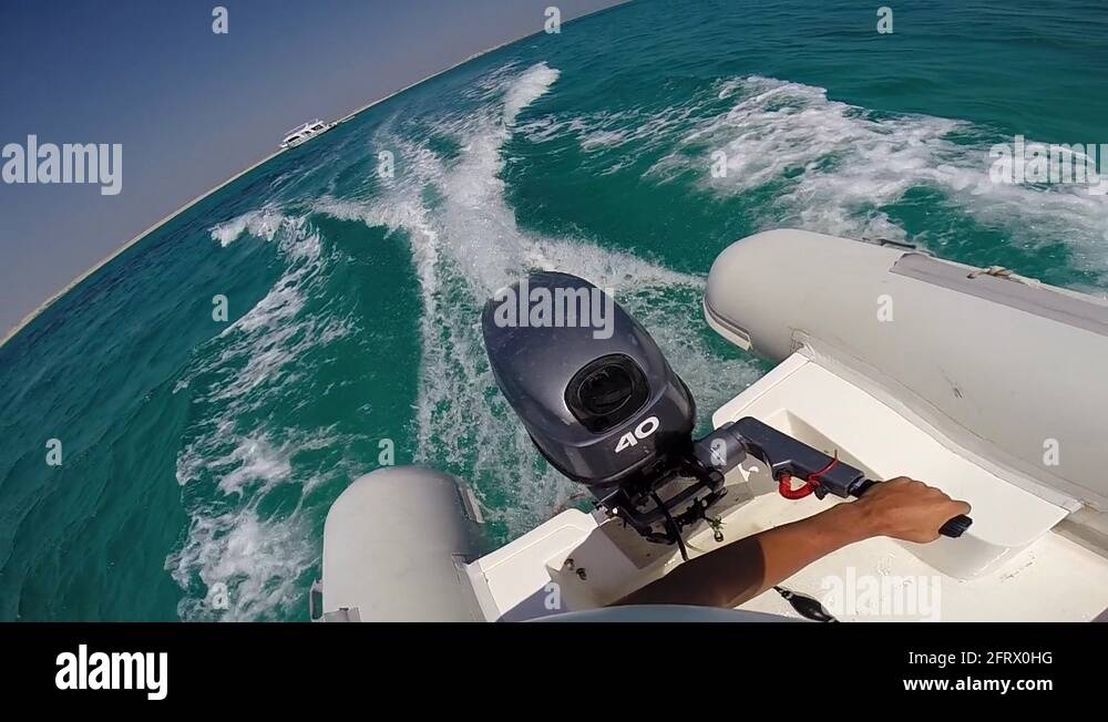 POV of a man steering an outboard engine in an inflatable boat in the ...