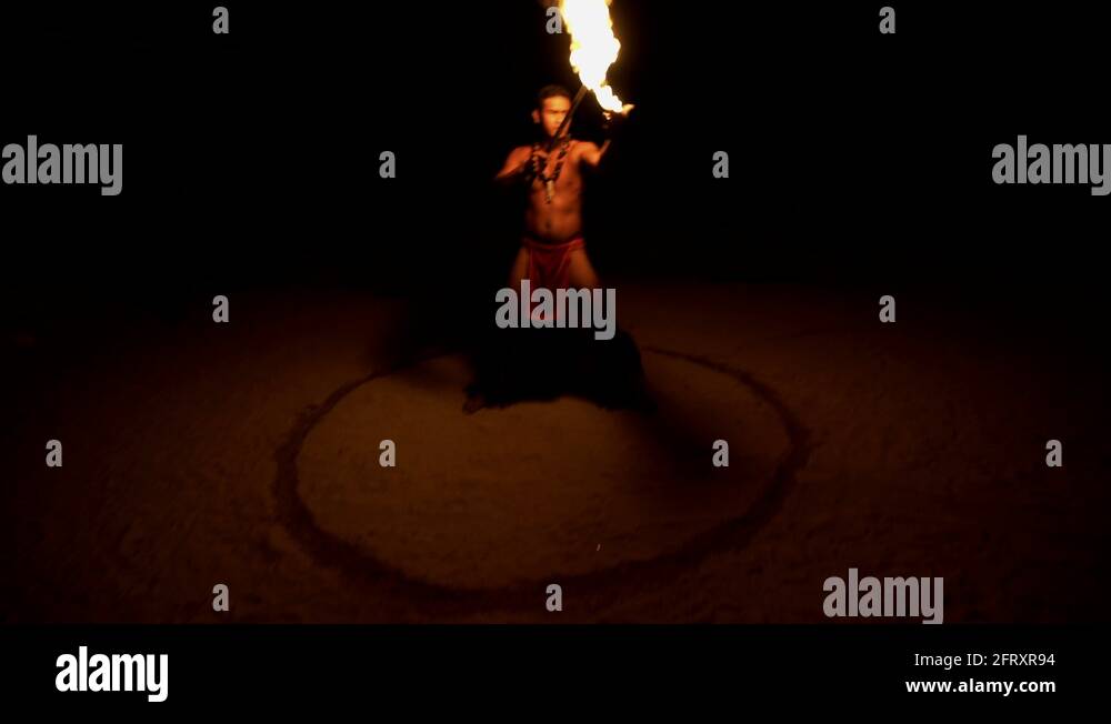 Polynesian male Fire dancer performing in a Ring of Fire while spinning ...