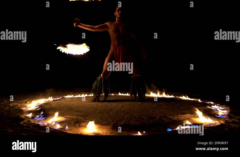 Polynesian male Fire dancer performing in a Ring of Fire while spinning ...