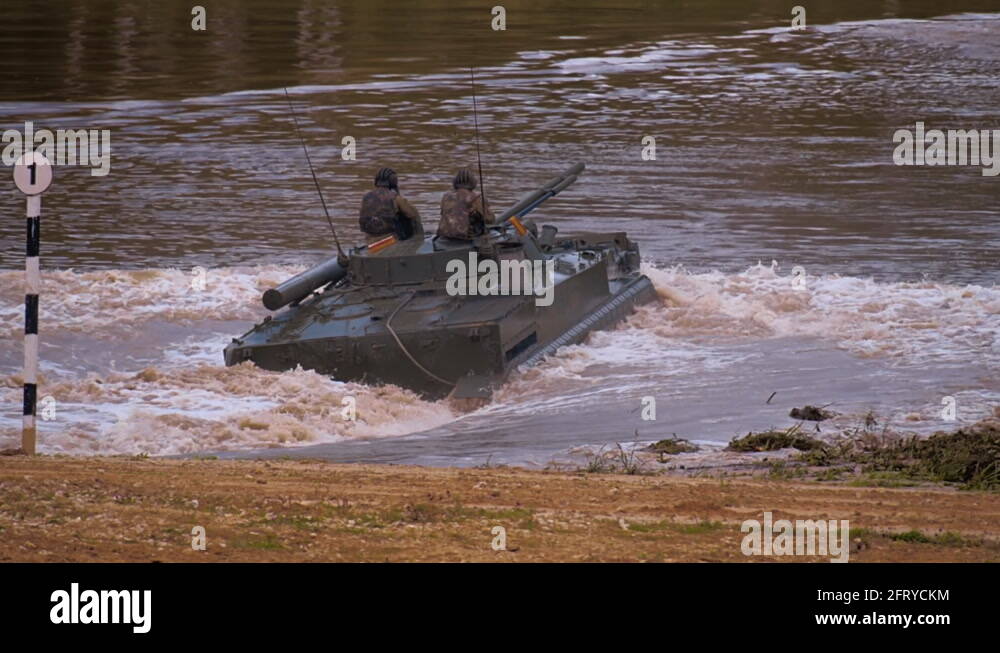 Armored military BMP and soldiers on the board are cross the river ...
