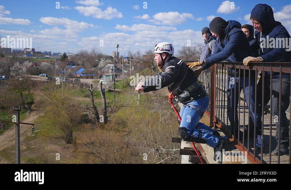 bearded biker jumps off a bridge facing forward Stock Video Footage - Alamy