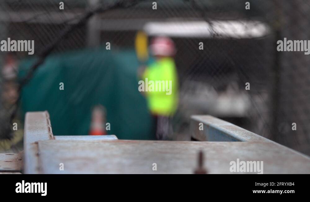 A vintage pitching machine throws a yellow baseball towards a batter ...