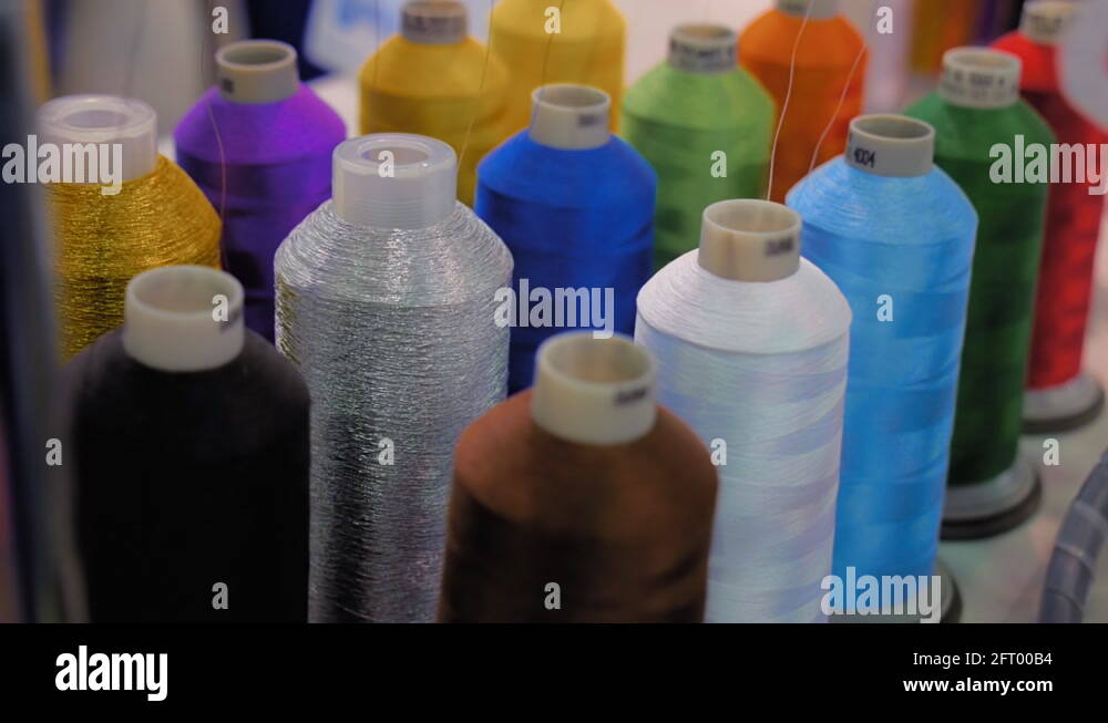 Rows spools of thread of different colors in the industrial sewing ...