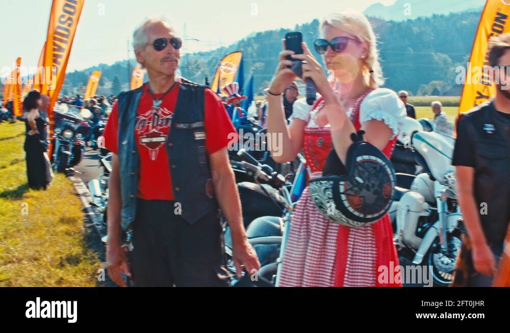 Woman in a red dress is filming motorbikes at a motorcycle parade Stock ...