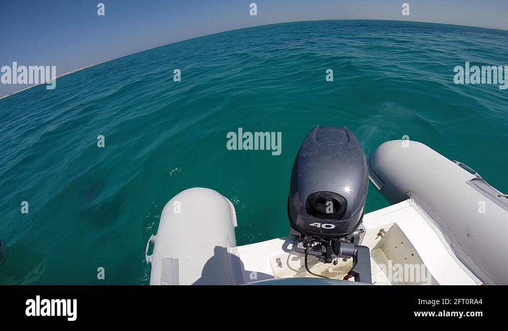 POV of a man steering an outboard engine in an inflatable boat in the ...