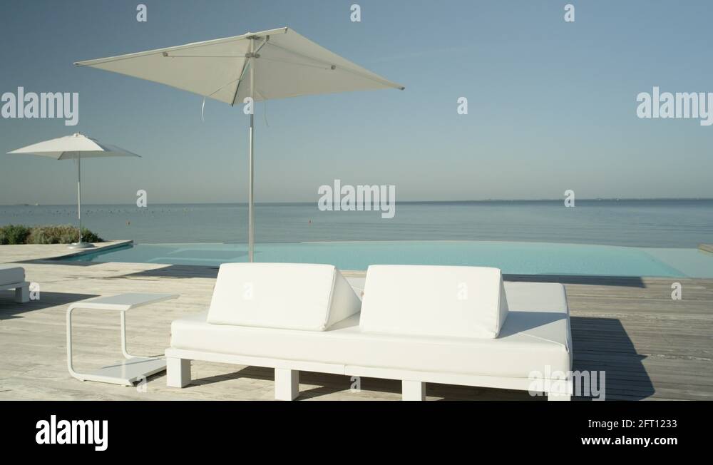 Luxury oceanfront high class resort with white daybed loungers and ...