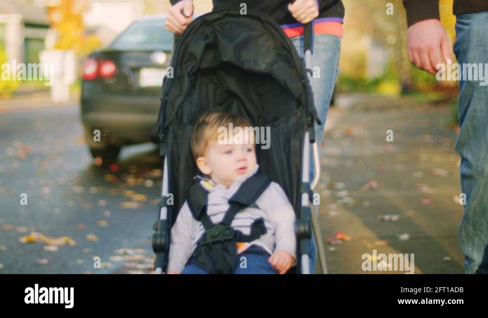 Adorable baby boy being pushed in a stroller, on a walk with his ...