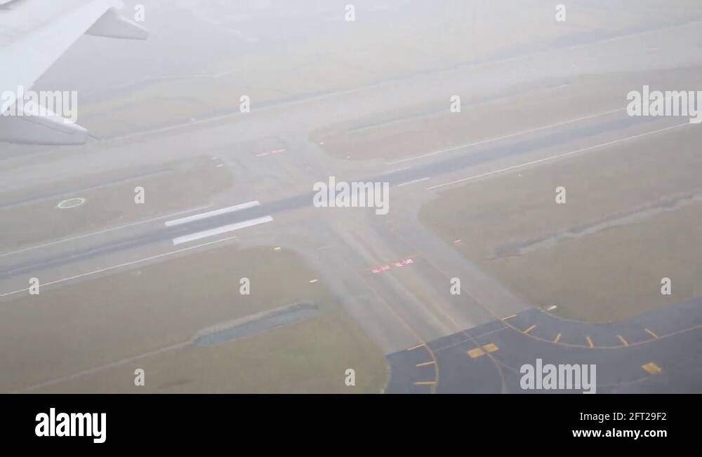 Part of wing of modern aircraft during flight over airport runways ...