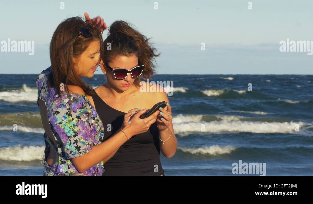 Girls on the beach having an amazing time while chatting on social ...