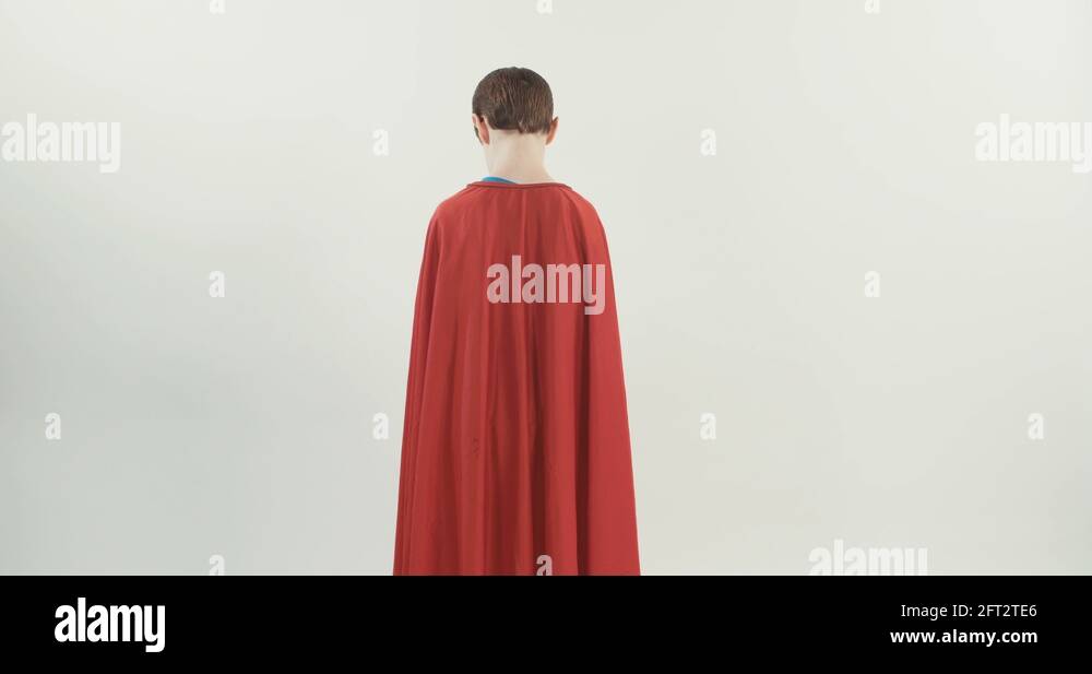 Boy wearing superhero cape on white background turns around Stock Video ...