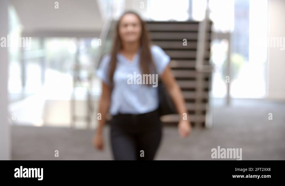 Female university student walking into focus in a stairwell Stock Video ...