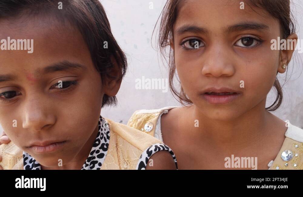 Two sisters looking at the camera with a serious and sad face, dolly in ...