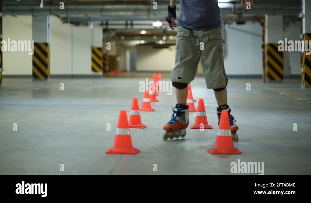 Man slowly circling lines of cones pushing legs backwards on roller ...