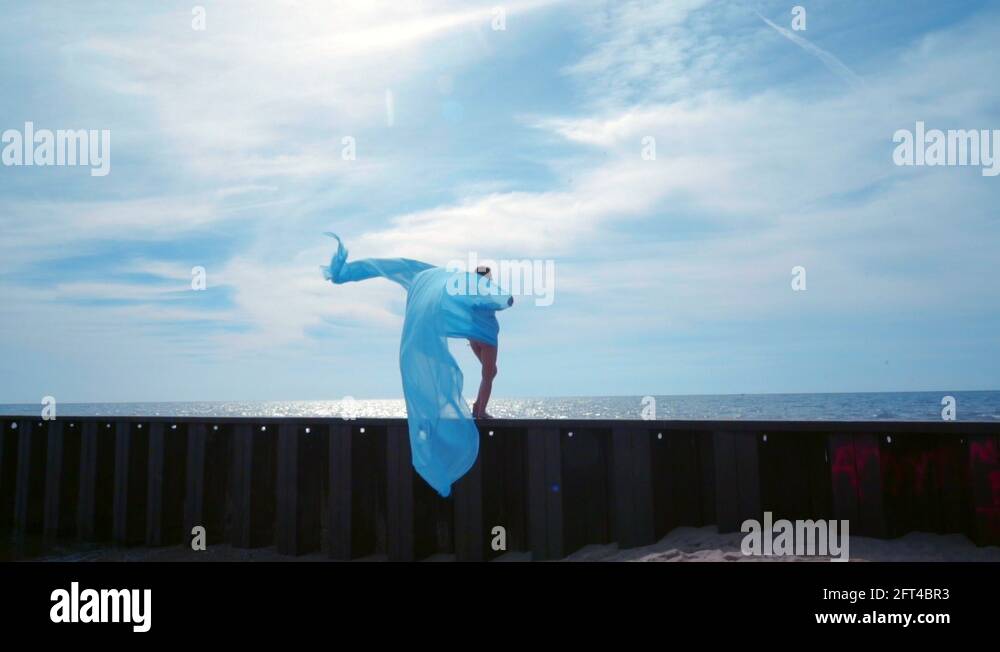 Romantic woman with cloth flying on wind on long pier. Freedom concept ...