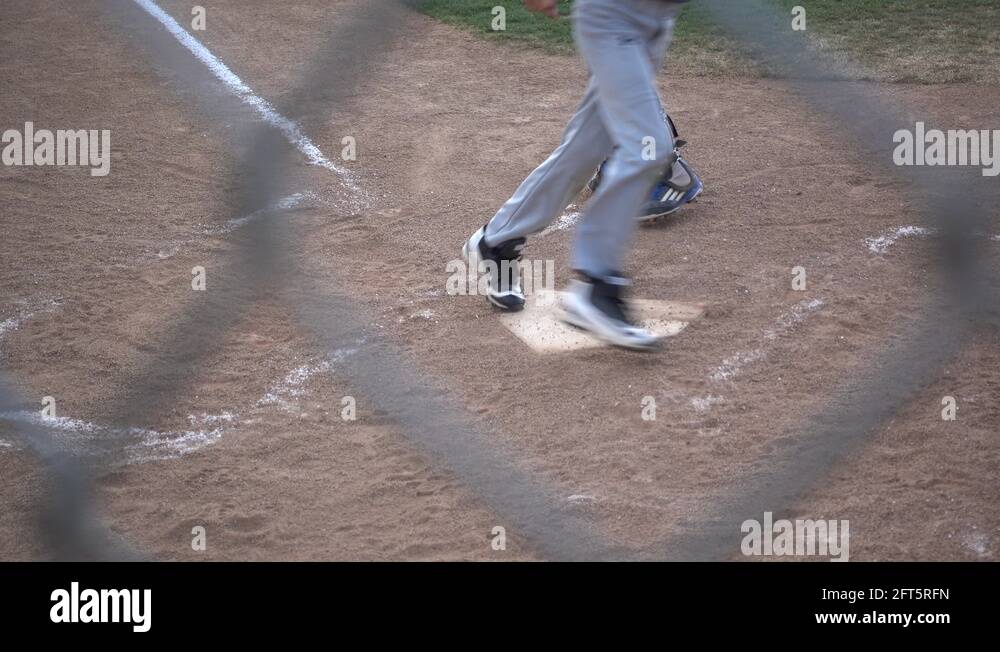 Boys playing in a little league baseball game through a chain-link ...