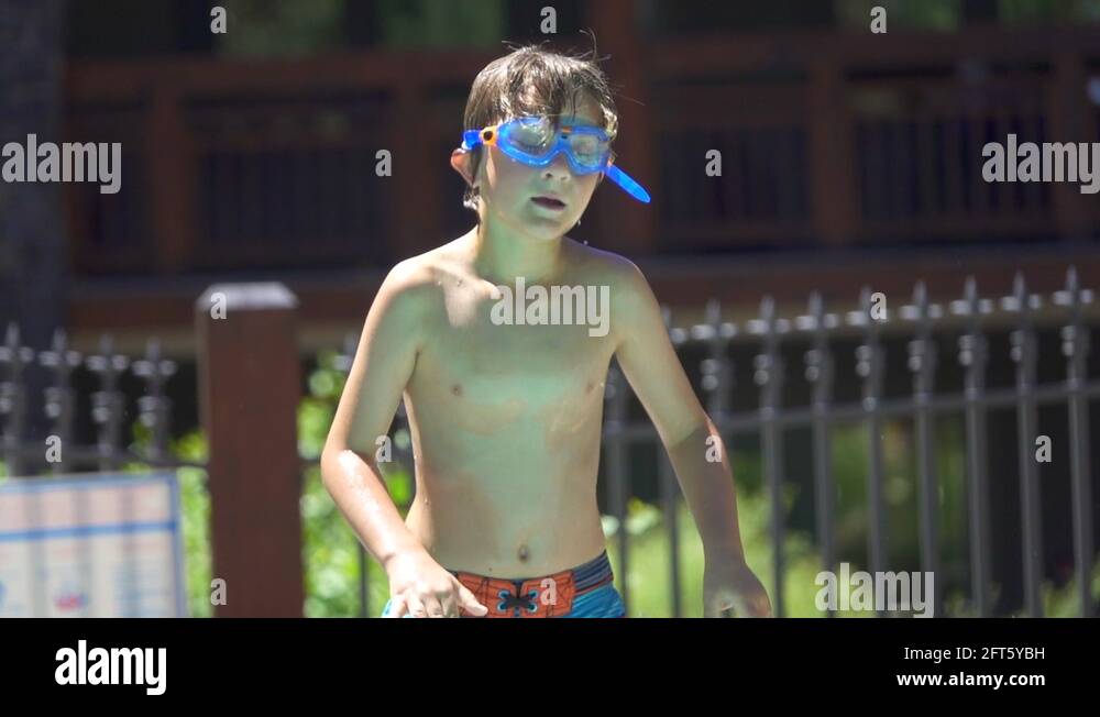 A boy jumps and does a cannonball into a pool at a hotel resort Stock ...