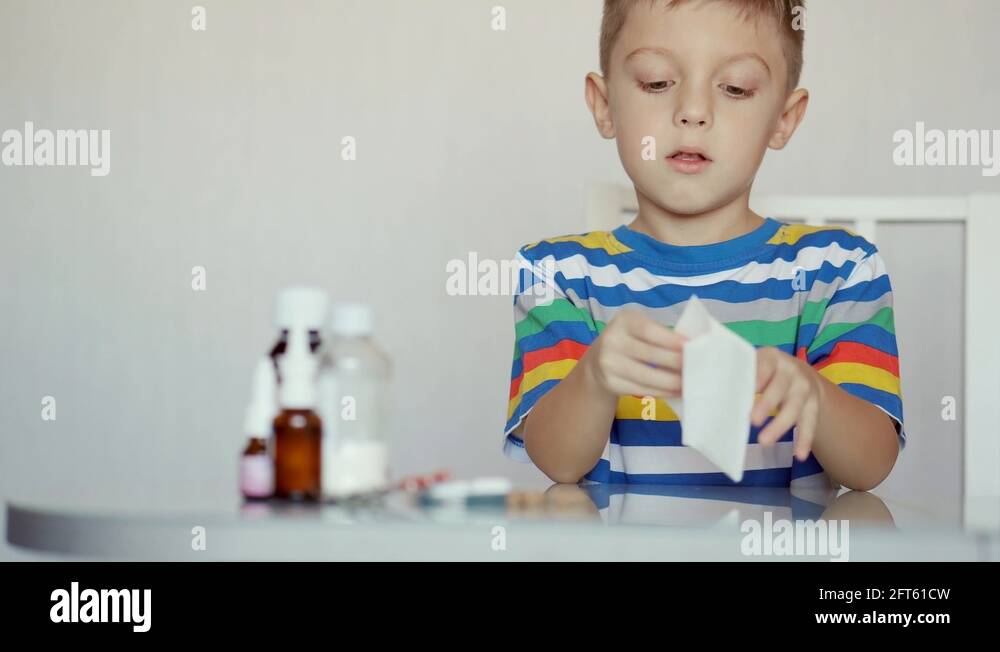 sick little boy blowing his nose into a tissue Stock Video Footage - Alamy