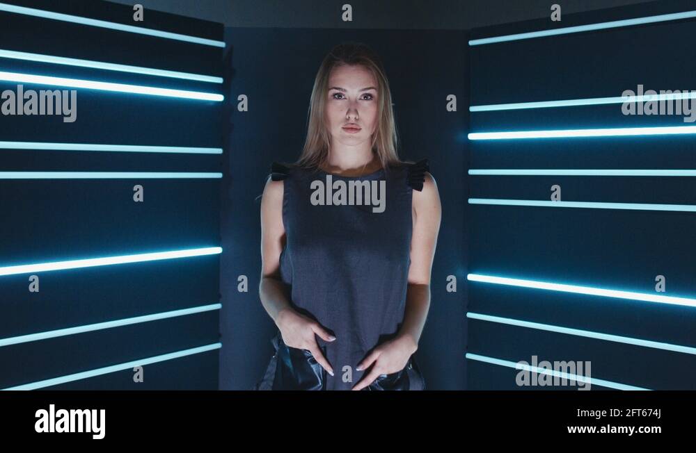 CINEMAGRAPH female fashion model standing in front of blinking light ...