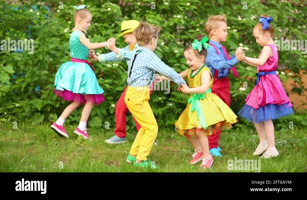 Six small girls and boys dancing in pairs holding hands on grass Stock ...