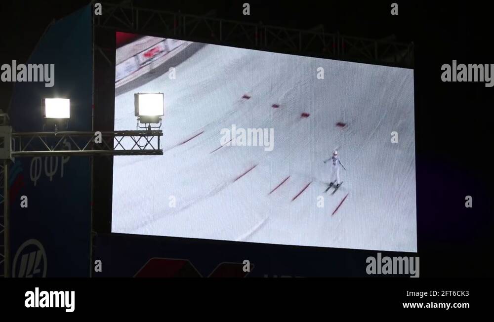 Sportsman in white jumping big ramp on screen on World Cup Freestyle ...