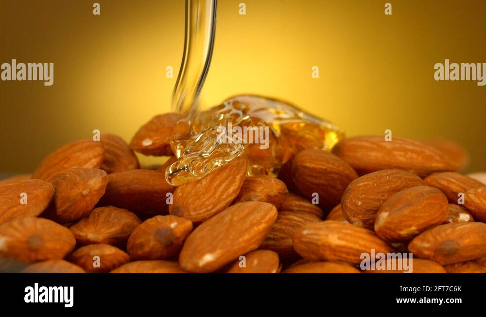 Honey pouring on almond nuts over yellow background. 4K UHD video Stock ...
