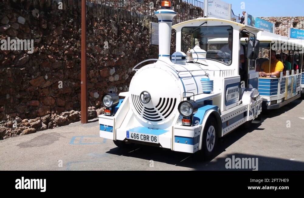 Tourist bus in the form of a steam train filled with people on the ...