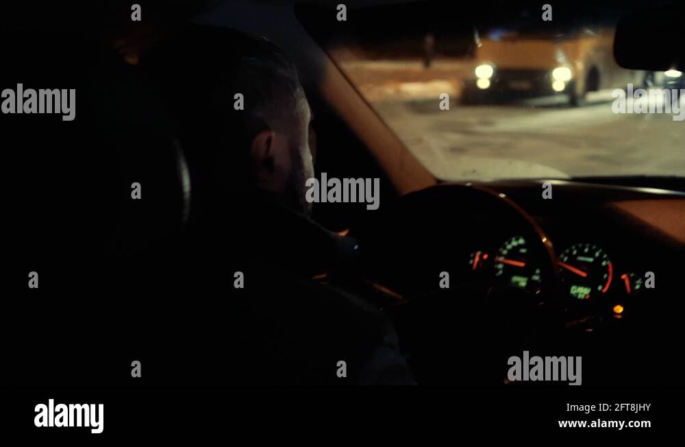 Man behind the wheel of a car driving on the evening streets Stock ...