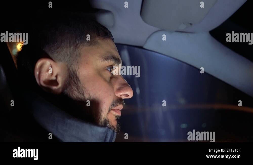 Man behind the wheel of a car driving on the evening streets Stock ...