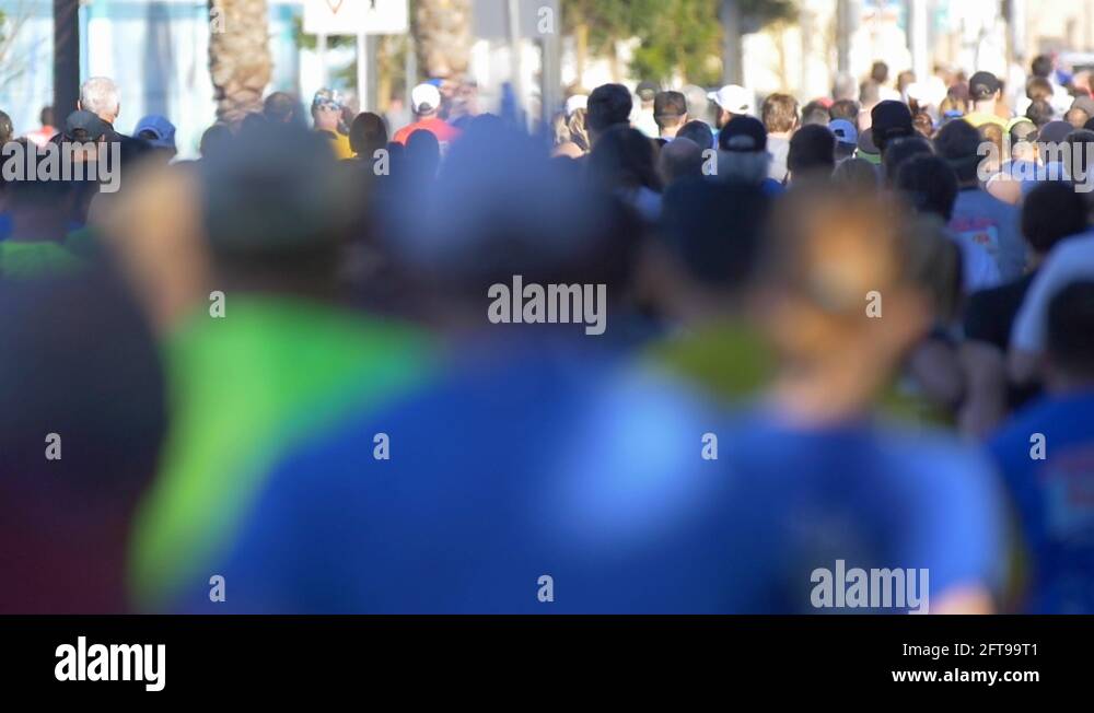 The back of a crowd of people running in a 10K race, slow motion Stock ...