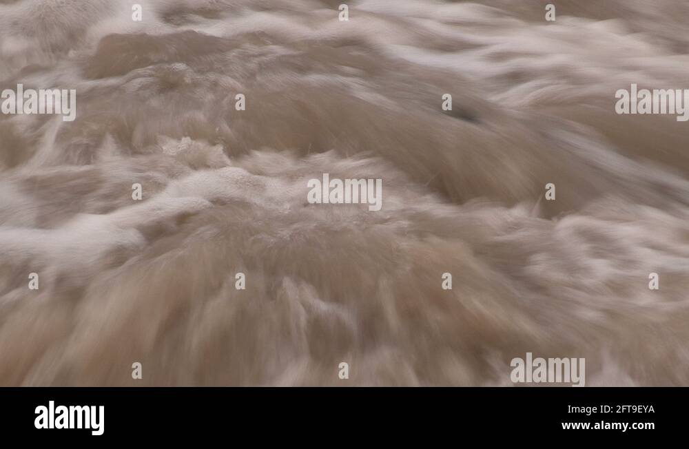 Spring river flooding and fast moving water in warm January weather ...