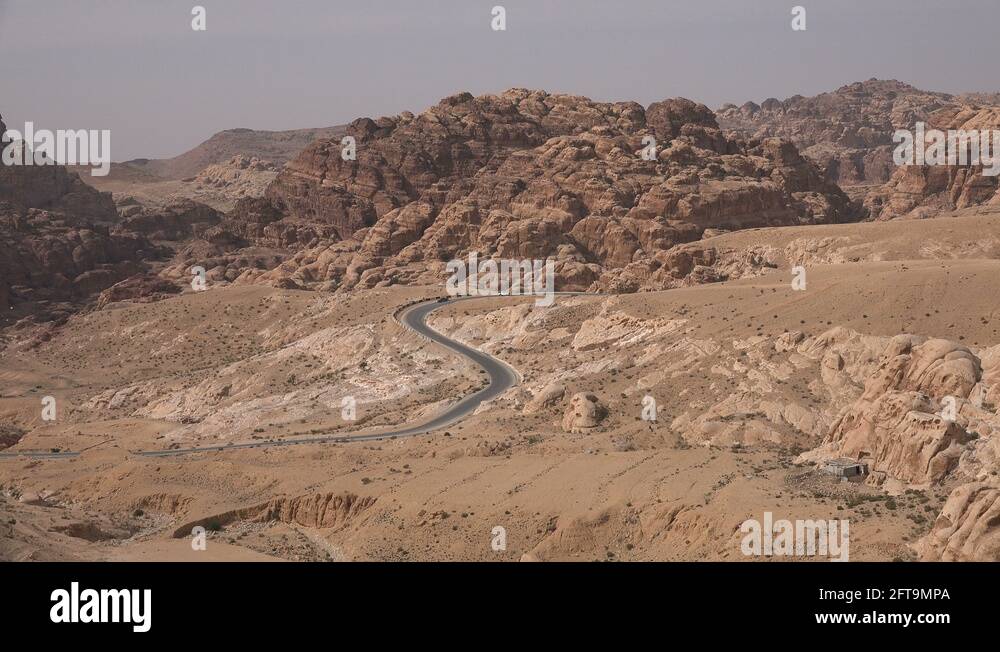 Cars drive through stunning mountain ranges in deserts of Jordan ...